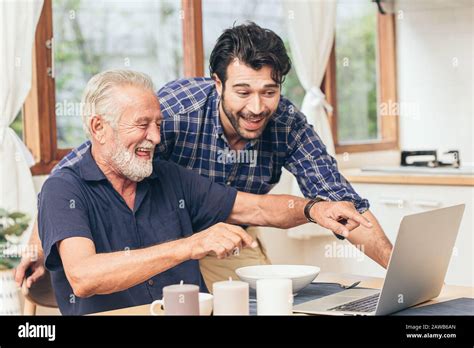 Old Man Fun Smile Happy To Looking At Laptop With Son Using Communication Technology For Family