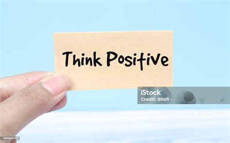 종이를 들고 여자 철자 단어 파란색 배경에 긍정적 인 생각 여성의 손에 Think Positive라는 문구가 적힌 찢어진 종이