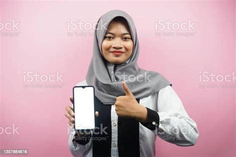 아름다운 젊은 아시아 무슬림 여성은 자신있게 웃고 흥분 손을 들고 스마트 폰을 들고 응용 프로그램을 제시 확인 사인 손 좋은 직업 성공 분홍색 배경에 고립 광고 개념 20