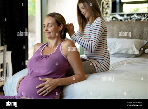 Young Pregnant Mother Enjoying Time At Home With Her Daughter Stock