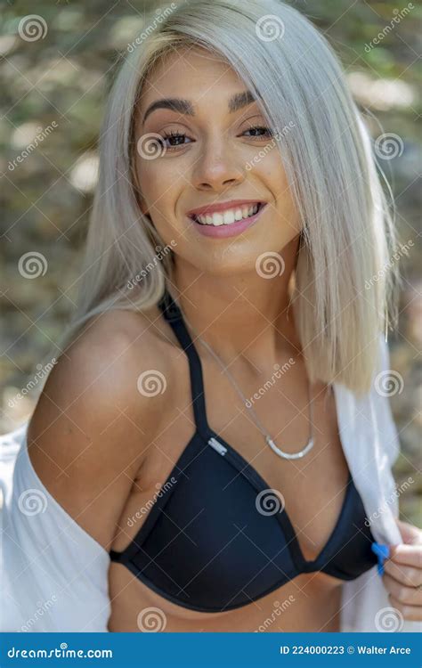 A Lovely Blonde Bikini Model Poses Outdoor While Enjoying A Summers Day