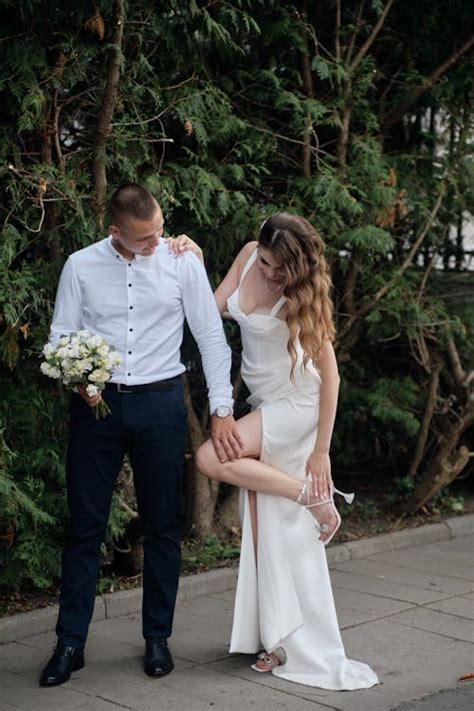 집 밖의 결혼 결혼 사진 결혼식 꽃 결혼식 전통 공식적인 옷차림 꽃다발 낭만적 인 순간 낭만적인 녹지 배경 단란함 로맨스 부부 포즈 부케 사랑