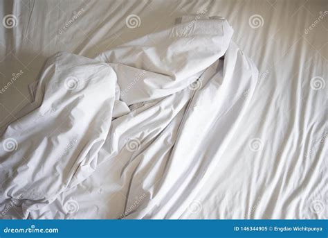 Unmade Bed Sheet Of The Crease And White Blanket In The Bedroom After