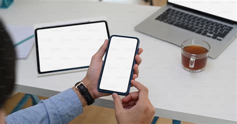 직장에서 여러 장치를 사용하고 빈 화면으로 스마트 폰을 들고 있는 사업가의 보기를 닫습니다 사진 Unsplash의 태국 이미지