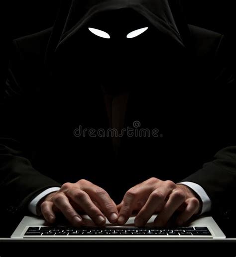 Mysterious Hacker In Dark Hoodie Typing On Laptop Illuminated Eyes Shadowy Figure Cybercrime