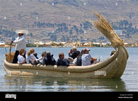 A Group Of Tourists Take A Trip On A Traditional Reed Boat On Lake