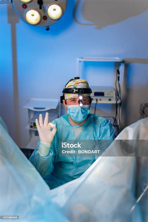 전문 남성 외과 의사 항문 전문의는 병원의 수술실에서 특수 의료 기기를 사용하여 수술을 수행하고 확인 표시를 보여줍니다 긴급 수술 개념 2명에 대한 스톡 사진 및 기타