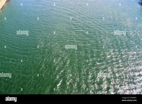 Detailed Close Up View On Water Surfaces With Waves And Ripples And The Sunlight Reflecting At