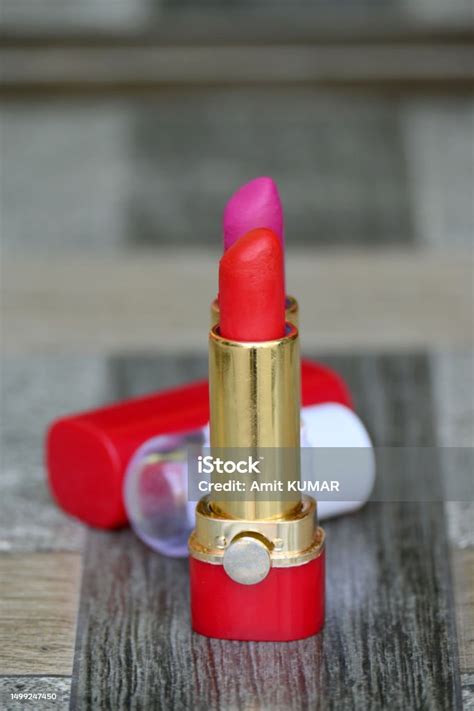빨간색과 흰색 모자가 있는 분홍색과 빨간색 립스틱 황금 튜브 한 쌍을 클로즈업하고 부드러운 초점 자연스러운 회색 갈색 배경을 닫습니다 다양에 대한 스톡 사진 및 기타 이미지