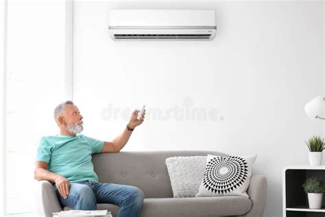 Mature Man Operating Air Conditioner While Sitting On Sofa Stock Image Image Of Cooler Adjust