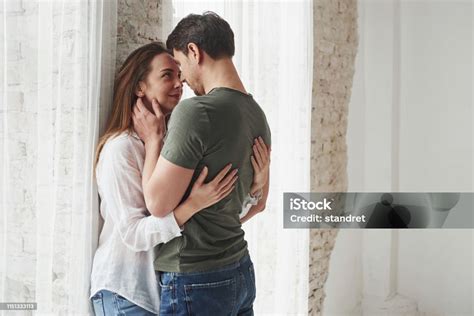 사랑 스러운 커플 키스 하 고 즐기는 각각의 다른 창에서 그들의 새로운 집 2명에 대한 스톡 사진 및 기타 이미지 2명 가정 생활 가정의 방 Istock