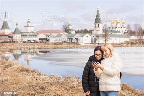 어머니와 딸은 고대 수도원과 푸른 호수가있는 봄 풍경을 배경으로 가족 셀카를 찍습니다 10 11세에 대한 스톡 사진 및 기타 이미지 10 11세 2명 40 44세