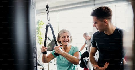 체육관에서 근력 운동을 하는 젊은 트레이너와 함께 쾌활한 여성 선배 사진 Unsplash의 활동적인 라이프 스타일 이미지