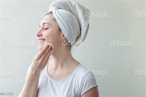 흰색 배경에 고립 된 면 패드를 사용 하 여 부드러운 건강 한 피부 제거와 머리에 수건에서 웃는 여자 건강한 생활방식에 대한 스톡 사진 및 기타 이미지 Istock
