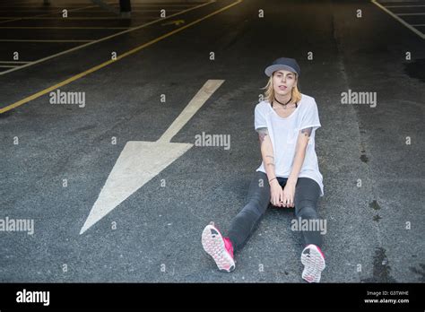 A Cool Young Tattooed Skater Girl Having Fun With A Skateboard Stock