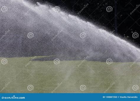 Sprinkler System Working On Fresh Green Grass On Football Socce Stock