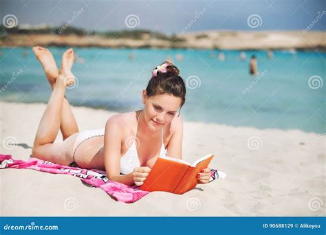Книга чтения молодой женщины на пляже моря Стоковое Изображение изображение насчитывающей