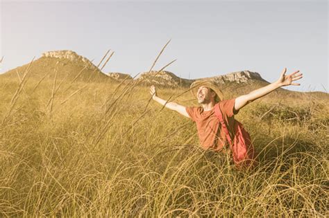 일몰의 황금 시간 동안 사막 여행 지역에서 행복으로 웃고있는 모자를 쓴 젊은 성인 백인 남자 복사 공간과 자연에서의 자유와 모험의 개념이있는 이미지 35 39세에 대한 스톡