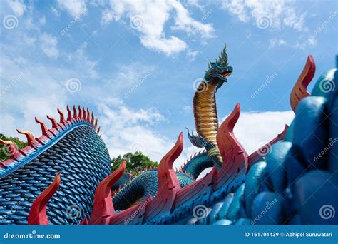 Giant Thai Naga Statue With Blue Sky Clouds In The Phu Manorom Temple