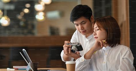 편안한 카페를 배경으로 나무 작업 책상에 앉아 컴퓨터 노트북과 문서를 가지고 함께 일하는 젊은 부부의 사진 사진 Unsplash의 태국 이미지