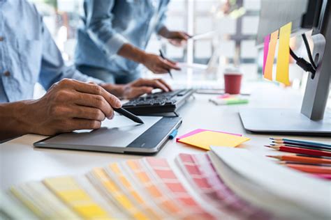 색상 선택 및 색상 견본에 작업 하는 두 동료 크리에이티브 그래픽 디자이너 작업 도구 및 액세서리와 직장에서 그래픽 태블릿에 그리기 2명에 대한 스톡 사진 및 기타 이미지