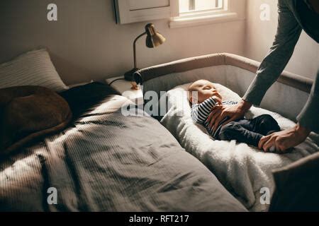 Mother Putting Baby To Sleep At The Crib Stock Photo Alamy
