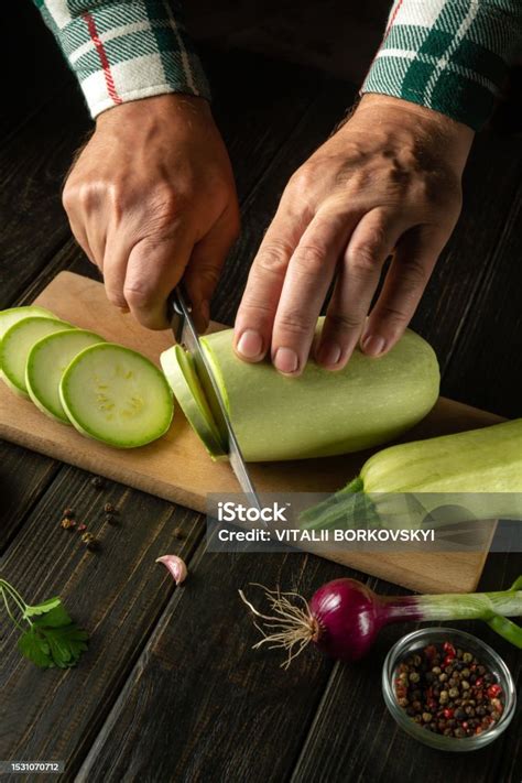 채식 음식을 준비하기 전에 나무 도마에 야채 골수 또는 호박을 칼로 자르는 요리사의 손 건강한 생활방식에 대한 스톡 사진 및