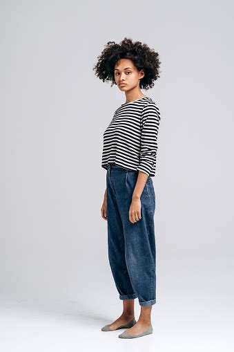 카메라를 바라보는 진지한 여성의 전체 길이 보기 자신감 집중 진지함을 표현 벗겨진 티셔츠를 입고 흰색 배경에 격리된 실내 스튜디오 촬영 25 29세에 대한 스톡 사진 및