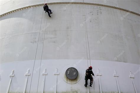 두께 저장 오일 및 가스 탱크 산업의 남성 작업자 로프 접근 높이 안전 검사 프리미엄 사진