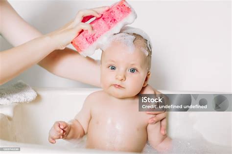 거품 거품으로 노는 목욕을하는 행복한 웃음 아기 욕조에 어린 아이 유아 세탁 및 입욕 인식 할 수없는 어머니는 흰색 작은 플라스틱 박쥐에 그녀의 아기를 목욕 가정 생활에