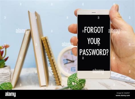 Smartphone In Hand With The Inscription Forgot Your Password Next To Office Supplies Stock