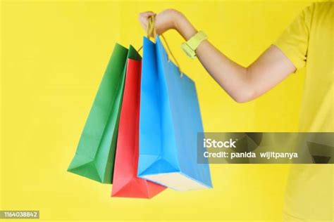 노란색 배경에 고립 된 쇼핑 백을 들고 예쁜 아이 소녀 손 아시아 젊은 여자 행복 한 여름 쇼핑과 휴일을 즐긴다 가방에 대한 스톡 사진 및 기타 이미지 Istock
