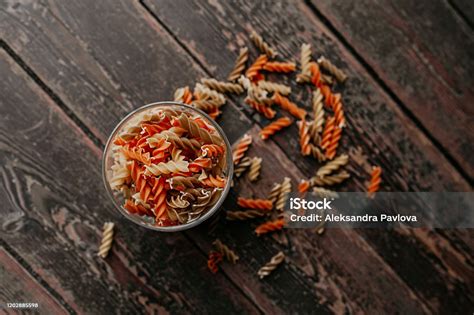 부엌에서 스마트 식품 저장 옵션 생 파스타와 주위에 흩어져 있는 오렌지 나선형 파스타를 저장하기위한 유리 항아리 곡초류에 대한 스톡 사진 및 기타 이미지 Istock