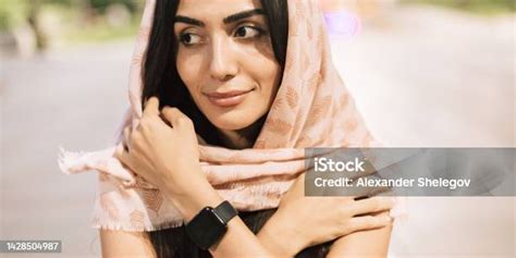 히잡처럼 분홍색 머리 스카프를 입은 아름다운 무슬림 여성의 여성 초상화 좋은 동양 사람들의 라이프 스타일 사진 소녀는 어두운 피부와 갈색 눈을 가진 갈색 머리입니다 아랍어