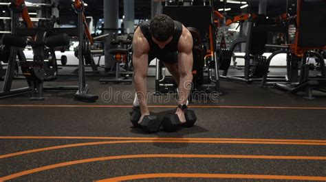 Fit Man Lifting Dumbbells While Planking Athlete Performing Dumbbell Plank Row In Fitness Gym