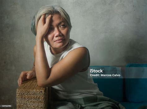 성숙한 여성 위기 회색 머리 슬프고 소파에 우울 한 중년 여성의 실내 라이프 스타일 초상화는 고독한 고통 우울증에 대한 좌절과 외로운 생각에 우울 50 59세에 대한 스톡