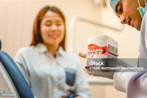 치과 의사는 클리닉에서 검사 및 치과 치료를 위해 환자를 설명하기 위해 치과 모델을 지적했습니다 치과 의사 도구 및 장비 25 29세에 대한 스톡 사진 및 기타 이미지