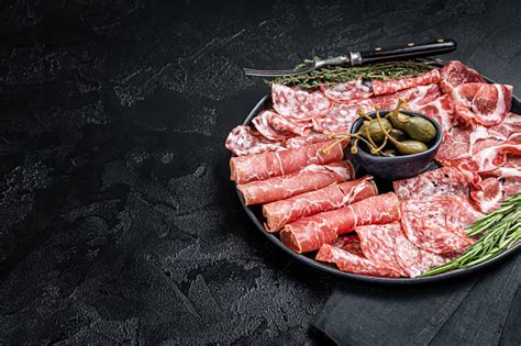 프로슈토 크루도 살라미 코파 소시지를 곁들인 이탈리아 안티파스토 세트 플래터 경화 고기 접시 검은 색 배경 맨 위 보기입니다 복사 공간 샤퀴트리에 대한 스톡 사진 및 기타