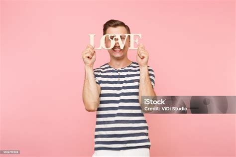 줄무늬 T셔츠에 감정적인 젊은이의 초상화 나무 말씀 사랑 절연 파스텔 핑크 배경 추세에 개최 사람들이 진심으 감정 라이프 스타일 휴가 개념 복사 공간에 대 한 지역 광고