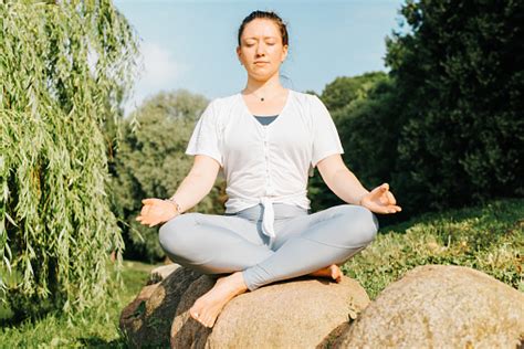 눈을 감고 자연에서 명상하고 요가 아사나를 연습하고 야외에서 연꽃 자세로 돌 위에 앉아있는 젊은 여성 요기 여성은 공원에서 아침 운동에 집중했습니다 요가와 명상 25 29