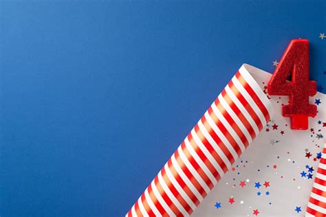 미국 독립기념일 축제 준비 반짝이는 색종이 조각이 특징인 애국심을 테마로 한 선물 포장의 평면도 4번 촛불은 생생한 파란색 배경에 감각을 더하고 텍스트나 광고를 위한 공간을