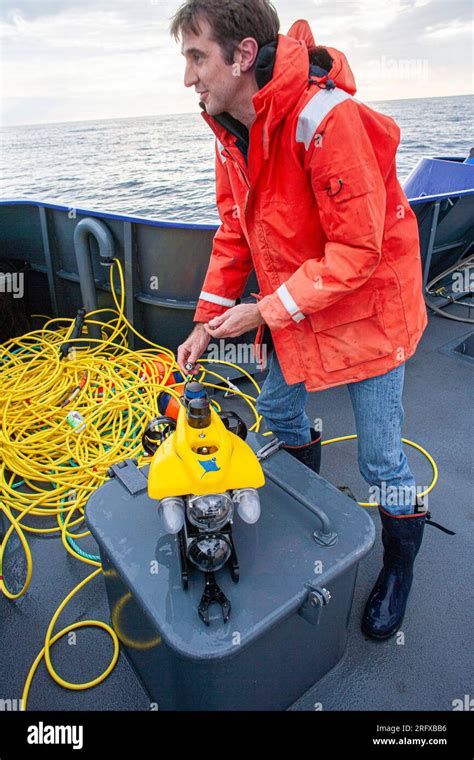 maritime scientist preparing a miniature remotely operated underwater