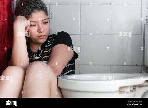 Beautiful Very Angry Latina Woman Sitting Next To The Toilet With One