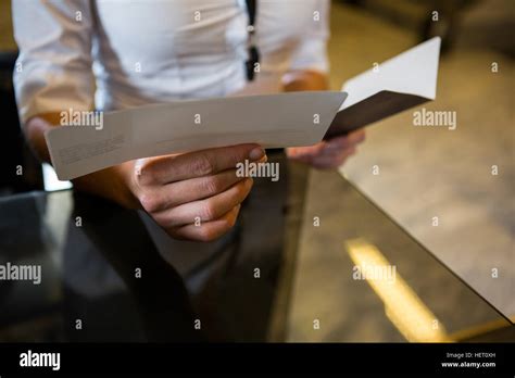 Businessman Checking Boarding Pass And Passport In Airport Terminal