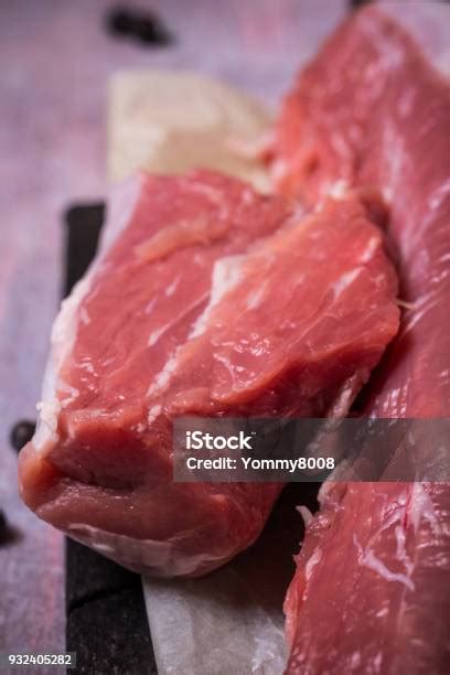 세로 사진 전체 돼지고기 안심의 세부입니다 생고기는 어두운 빈티지 나무 보드와 종이 시트의 작품에 있습니다 몇 주 니 퍼 열매는 주위에 음식을 흘 렸 어 0명에 대한 스톡