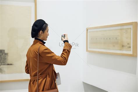 Literary And Artistic Young Beauty Taking Pictures With Her Mobile Phone While Watching The