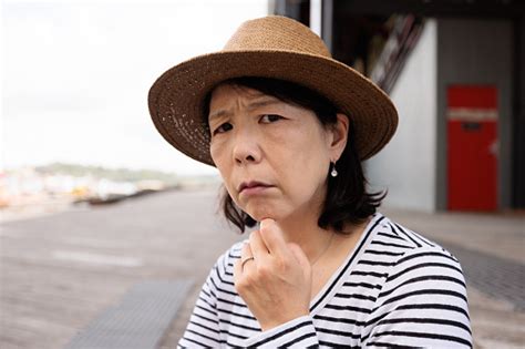 모자를 쓴 아시아 여성은 야외에서 짜증나고 의심스러운 표정으로 카메라를 바라보고 있다 사람들에 대한 스톡 사진 및 기타 이미지 사람들 찡그림 호주 Istock