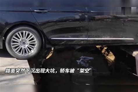 路面突然凹陷出现大坑小轿车被架空