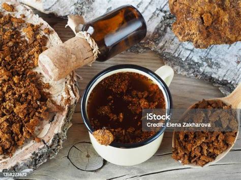 천연 자작 나무 차가 버섯 조각 병에 추출 한 추출물을 마시고 나무 배경에 머그잔에 차 상단 보기 의학 동종 요법에 사용하기위한