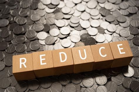 Premium Photo Wooden Blocks With Reduce Text Of Concept And Coins